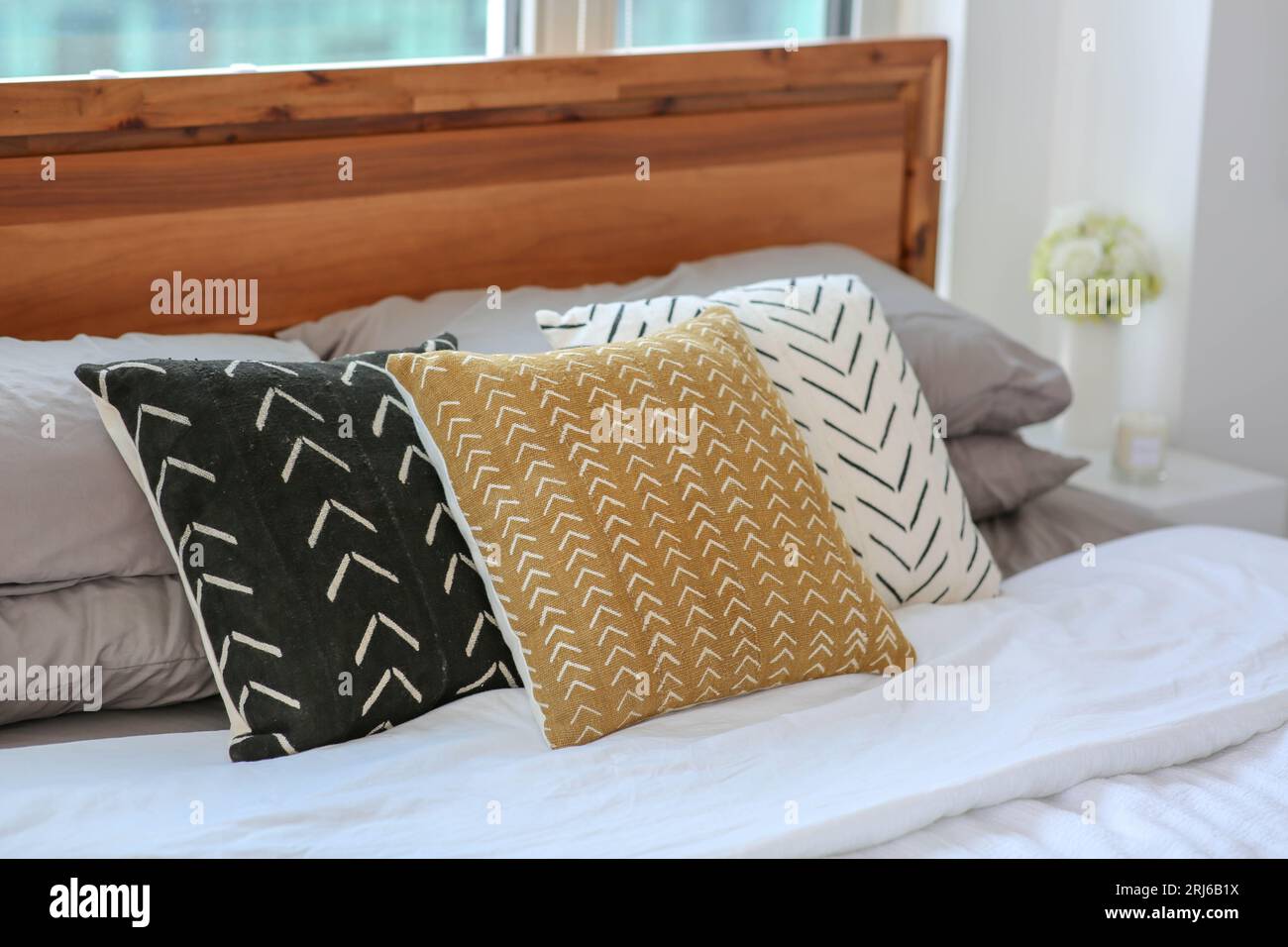 A bedroom featuring a bed with sheets and multiple decorative pillows ...