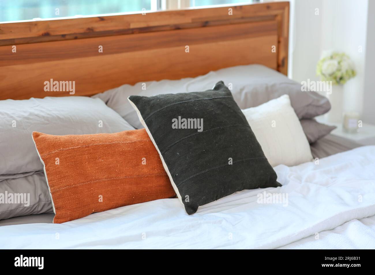A bedroom featuring a bed with sheets and multiple decorative pillows ...