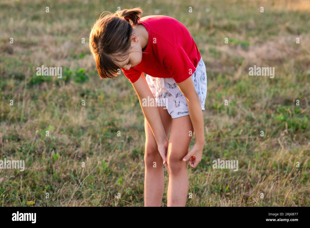 A child girl injured her knee in nature Stock Photo - Alamy
