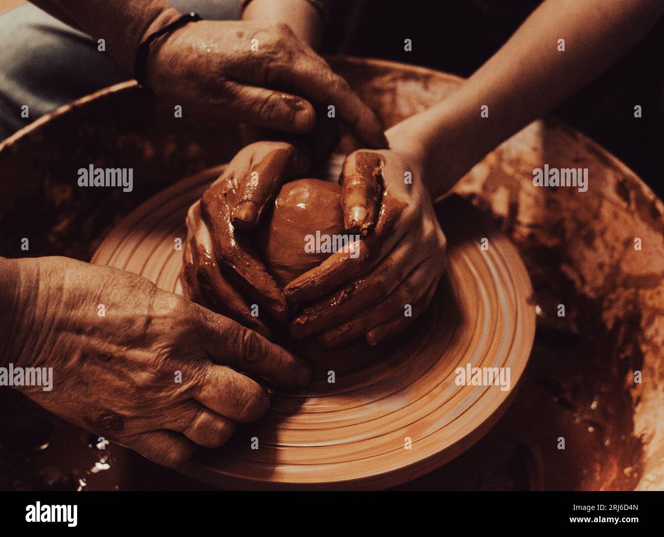 A person shaping a bowl of clay with their hands Stock Photo - Alamy