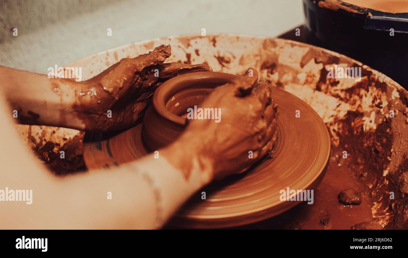 A person shaping a bowl of clay with their hands Stock Photo - Alamy
