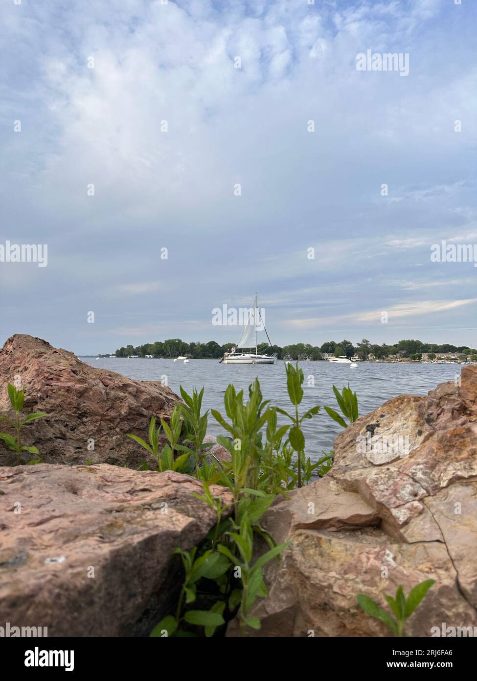 An idyllic landscape featuring a picturesque shoreline, with calm water ...