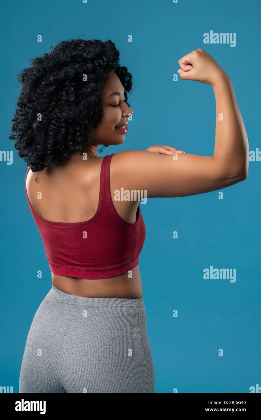 Athletic woman looking contented and showing her muscles Stock Photo ...
