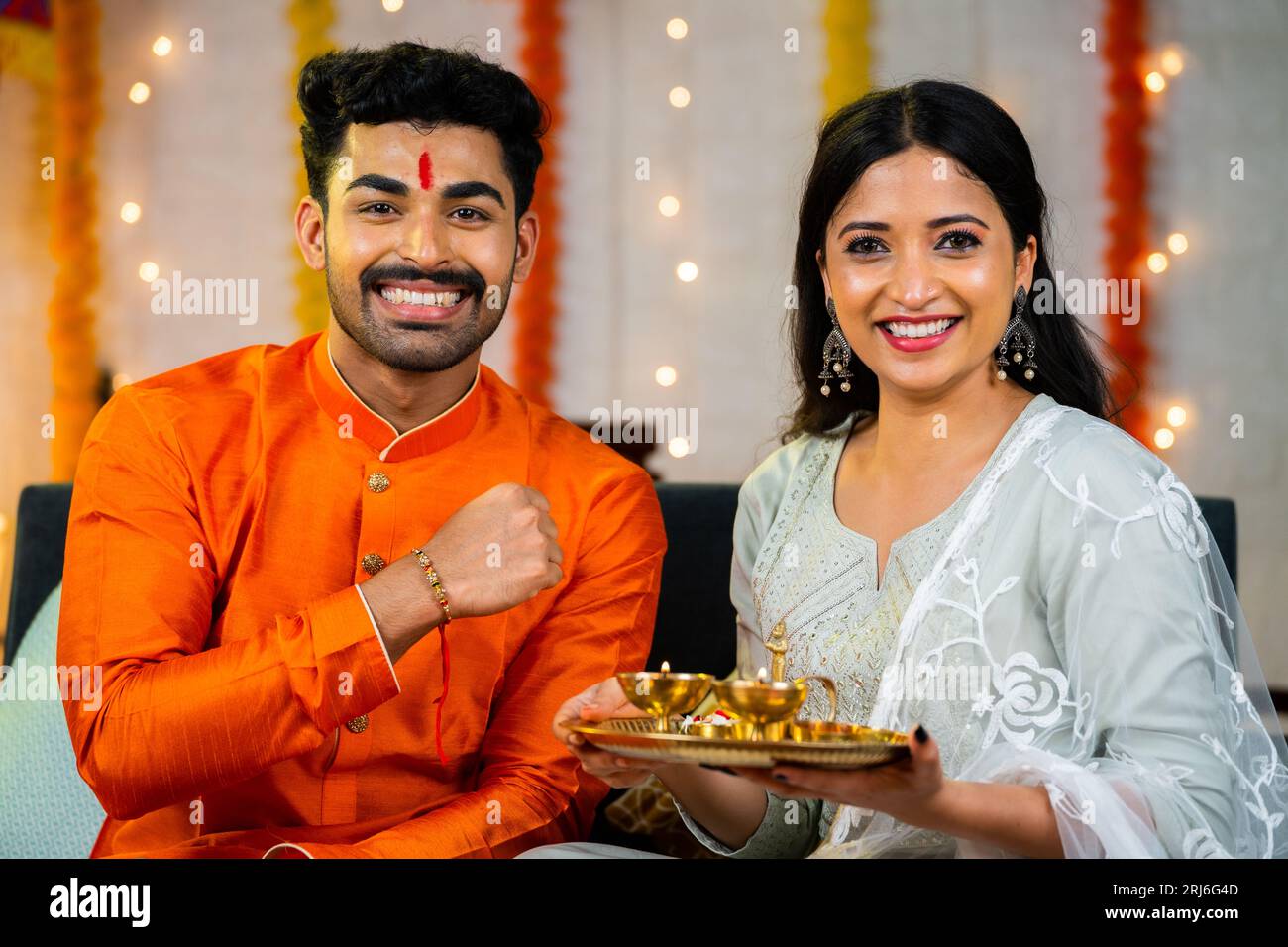 Happy smiling indian brother showing rakhi with sister by looking at ...
