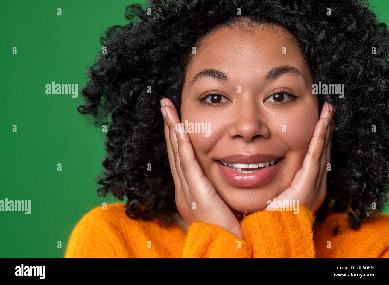 Happy dark-haired ypung woman in orange Stock Photo - Alamy