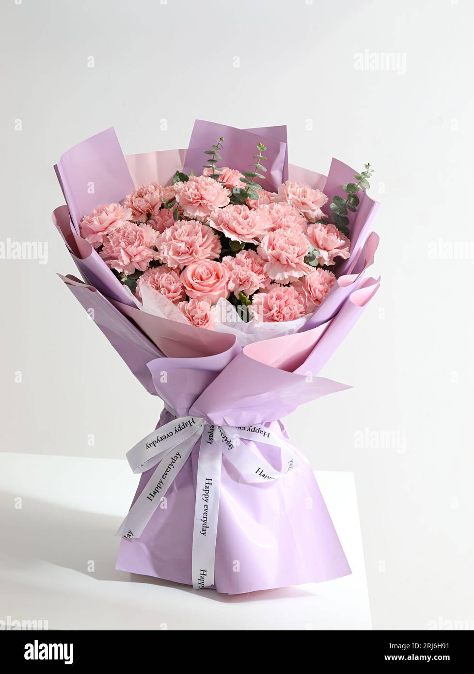 A vibrant bouquet of pink and white carnations and roses arranged ...