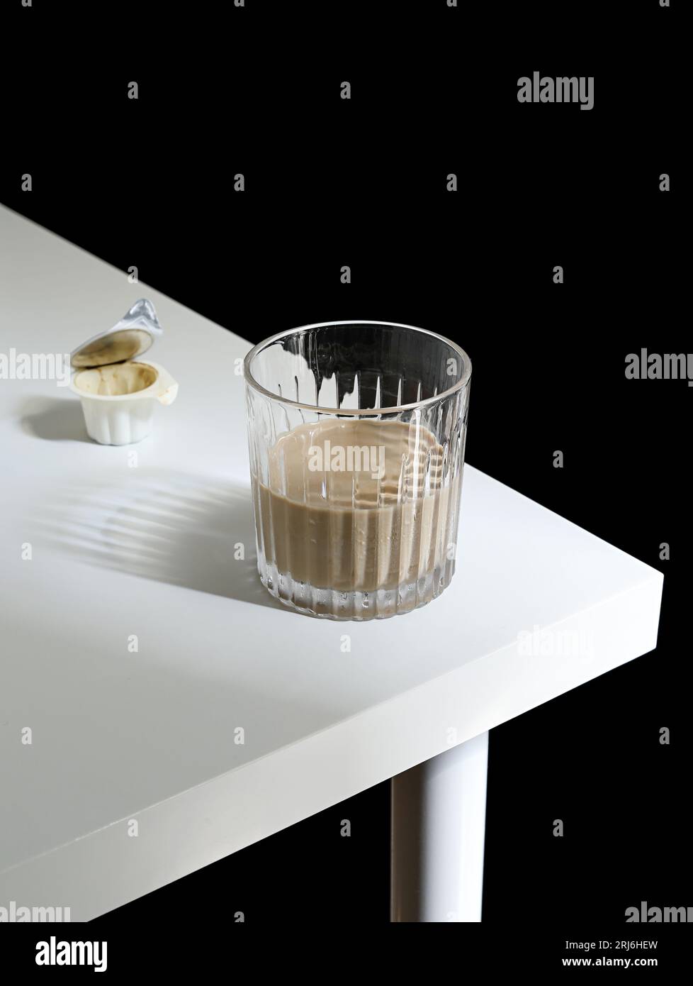 A refreshing iced coffee beverage with milk sitting on top of a pristine white table Stock Photo ...