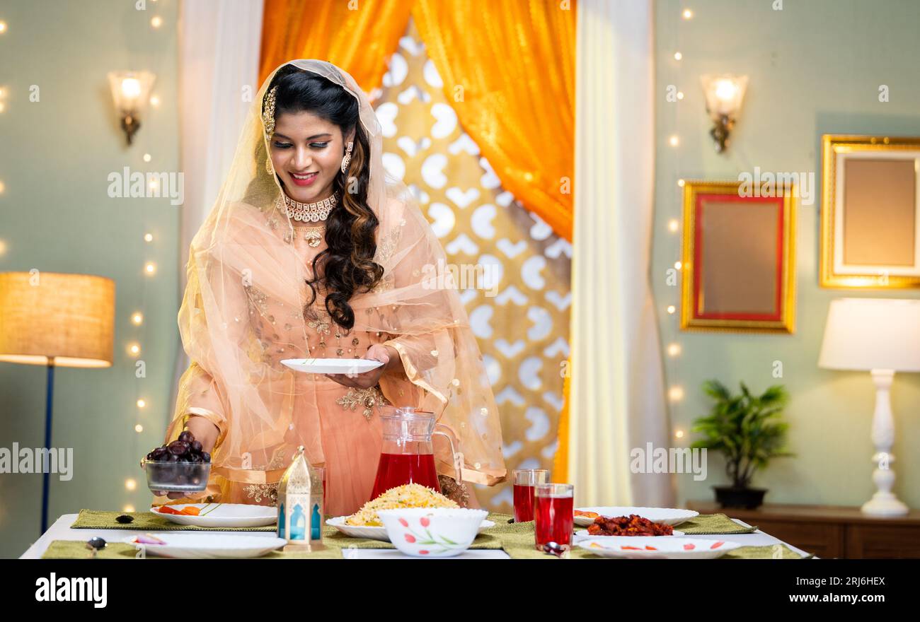 Happy indian woman arranging Ramadan feast or dinner at home during ...