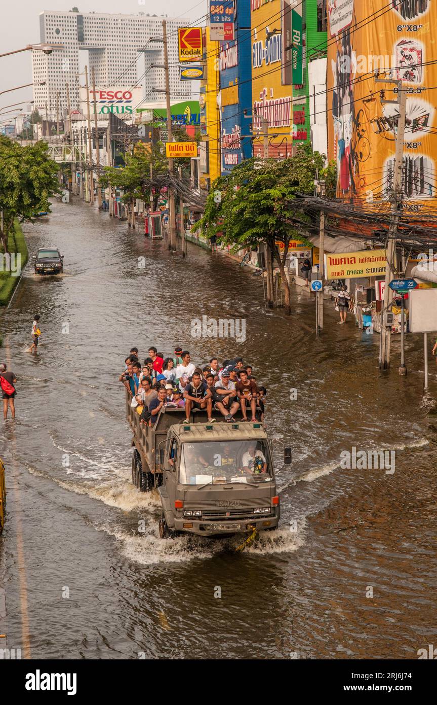 The climate crisis. Thai refugees flee flood on the back of a truck ...