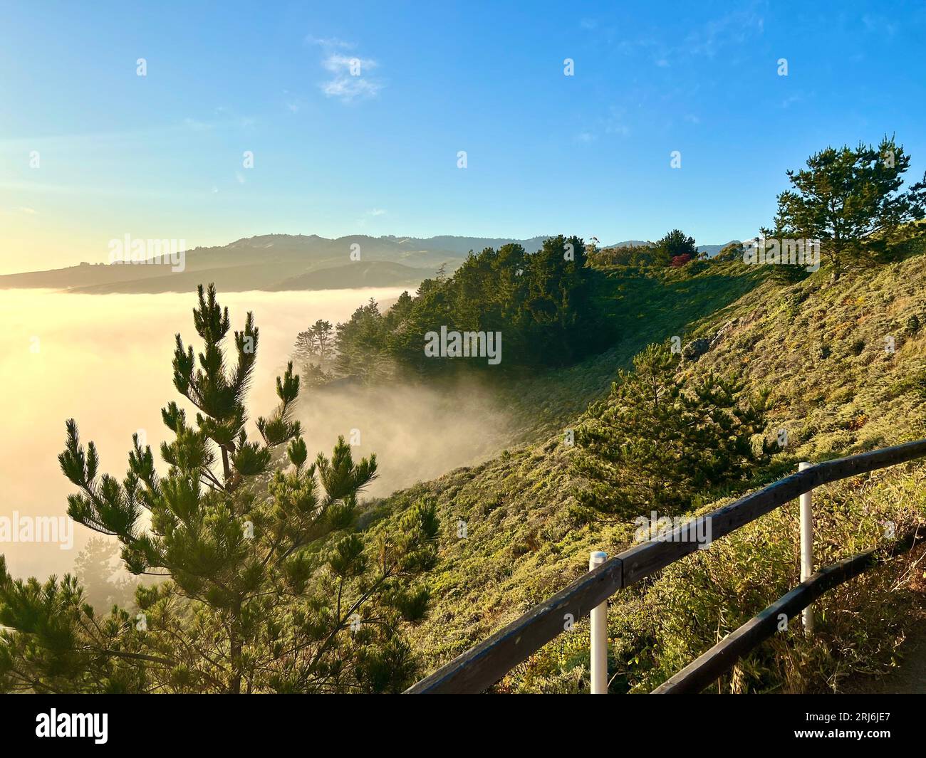 Aerial view of a pathway leading up to the entrance of a foggy mountain ...