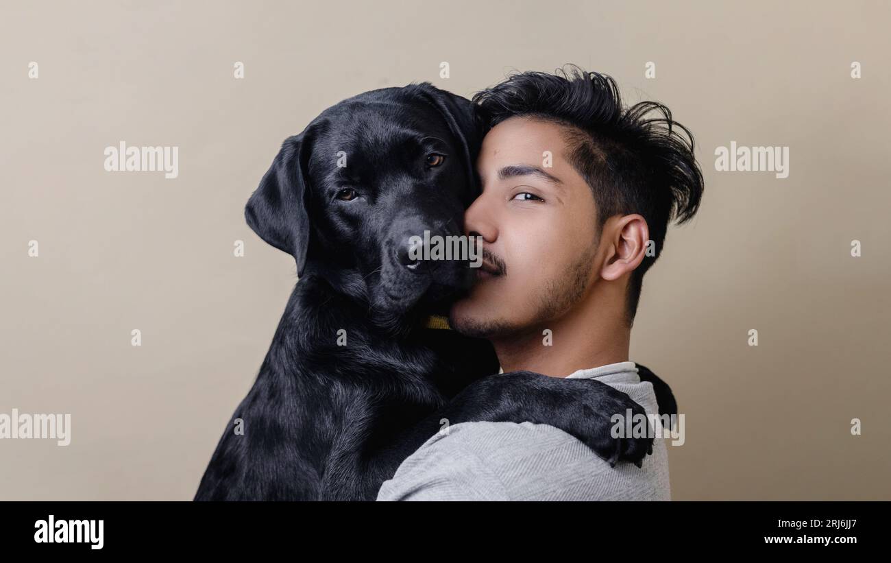 A black labrador hugging his human friend Stock Photo - Alamy