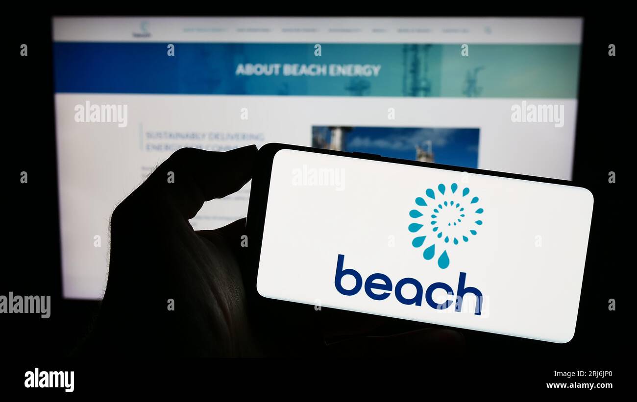 Person holding smartphone with logo of Australian oil company Beach ...