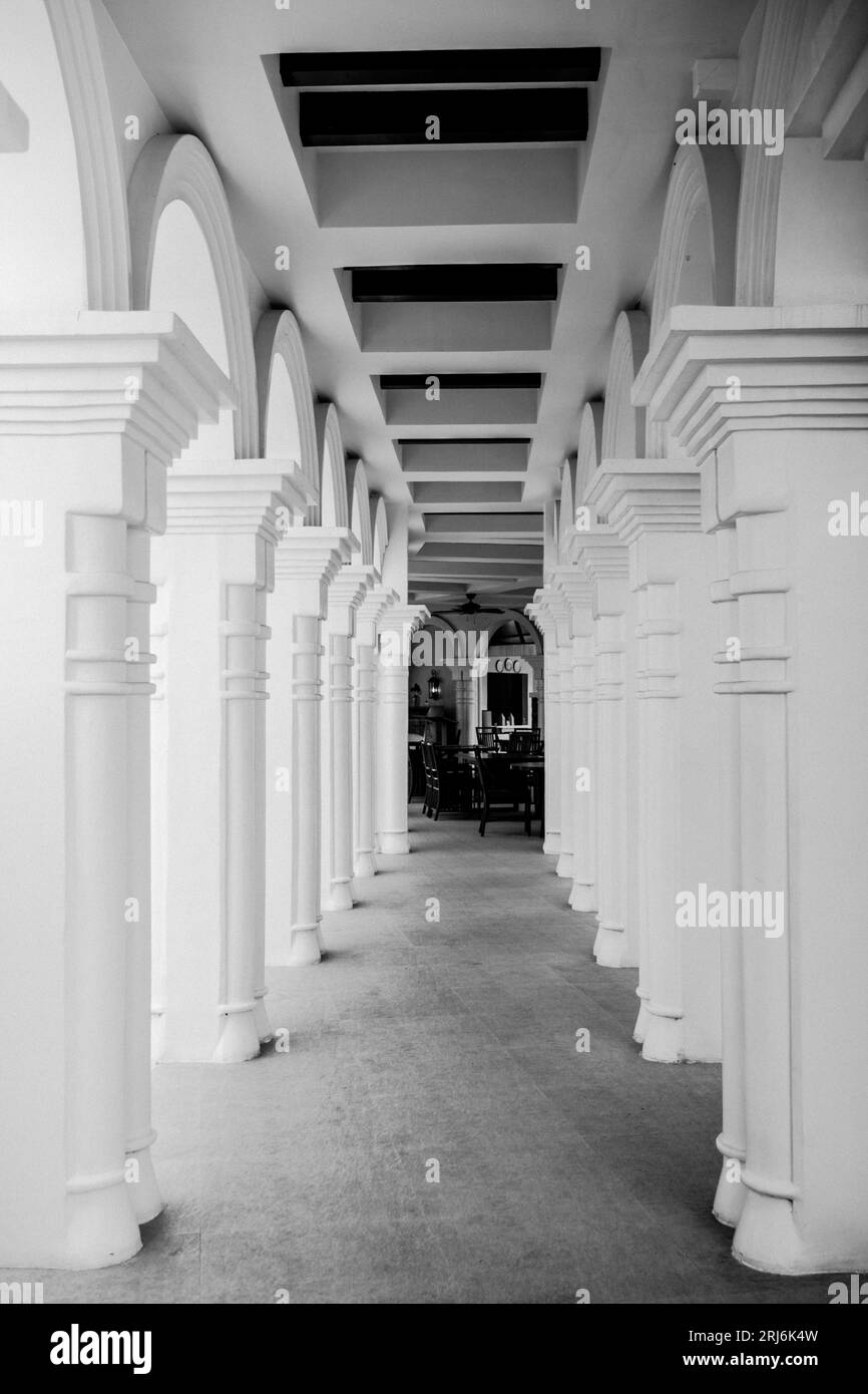 A hallway with multiple stone columns standing side by side, providing ...