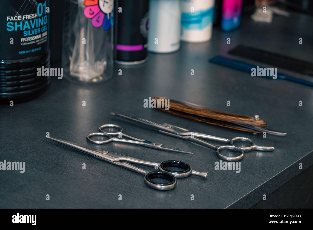 A collection of professional-grade scissors arranged on a white table ...