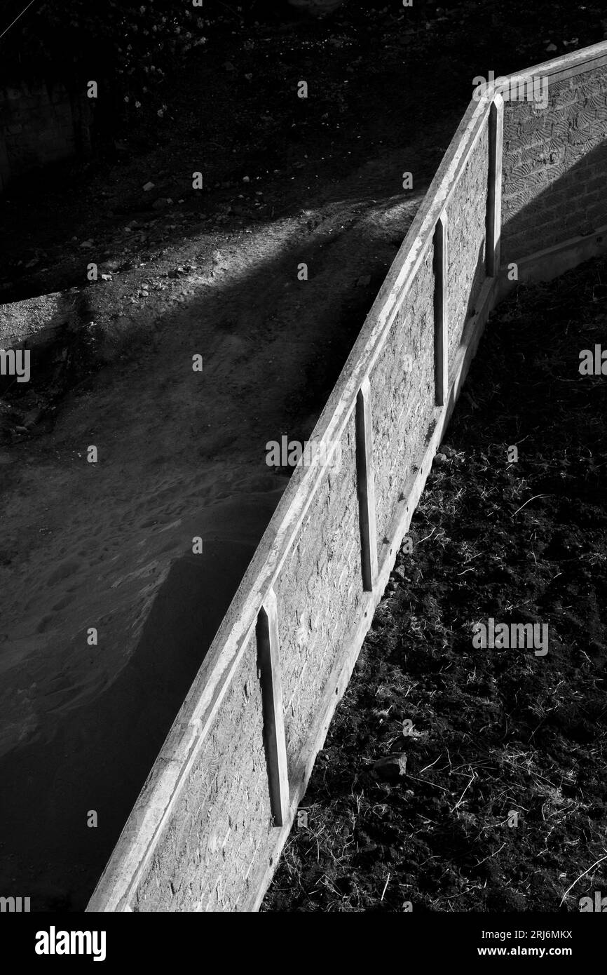 A high-resolution, black and white image of a brick wall with subtle ...