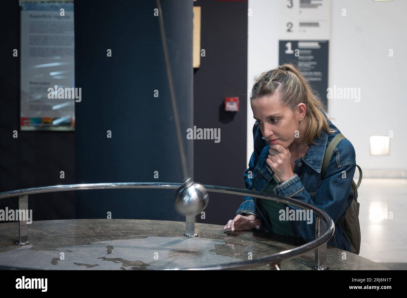 Young girl in museum science lab playing with pendulum Stock Photo - Alamy