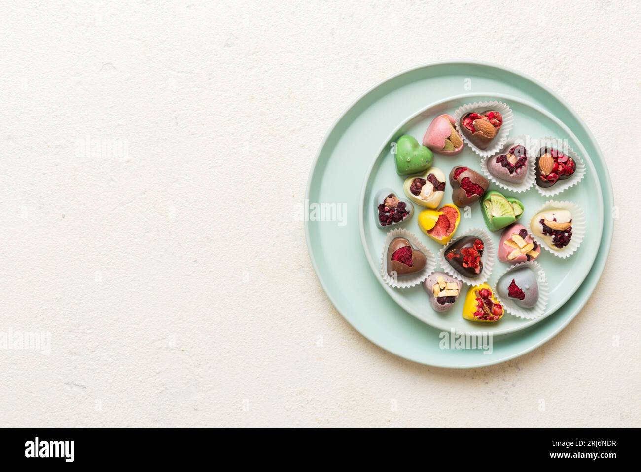 Plate with different chocolate on colored background. Assortment of ...