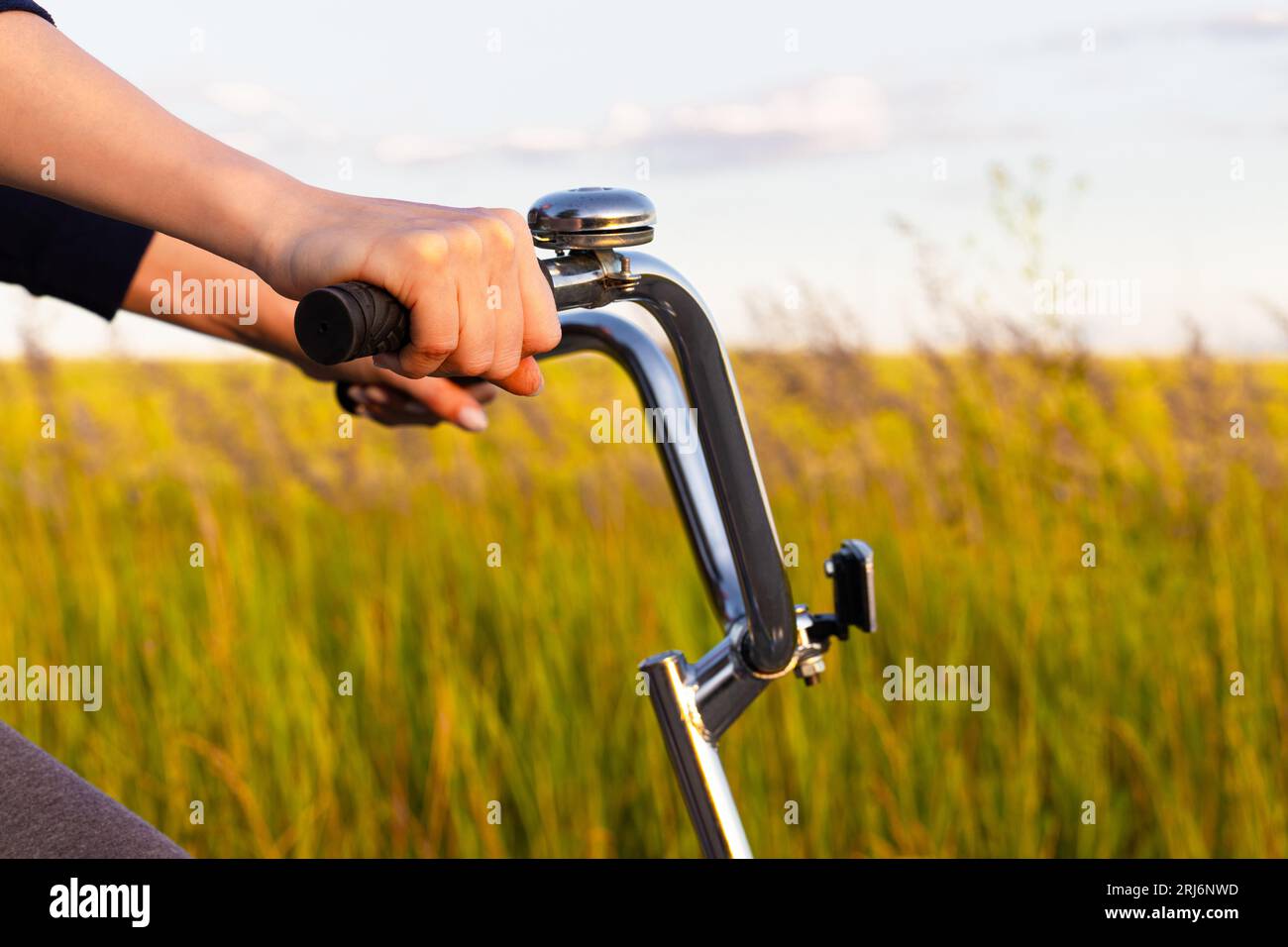 hand holding the handlebars of a bicycle. girl riding a bike on a ...