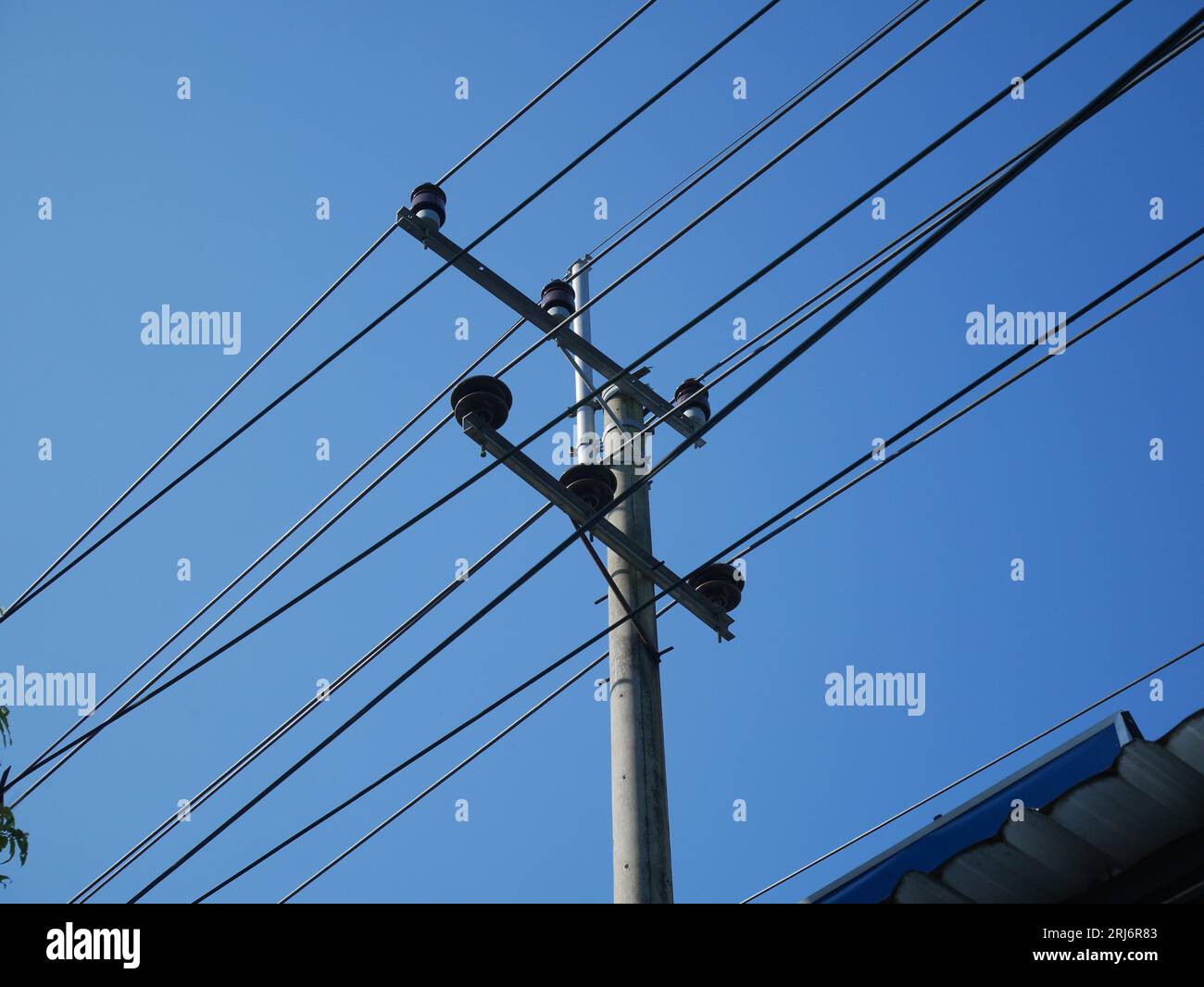 A close-up of a telephone pole with multiple electrical wires and ...