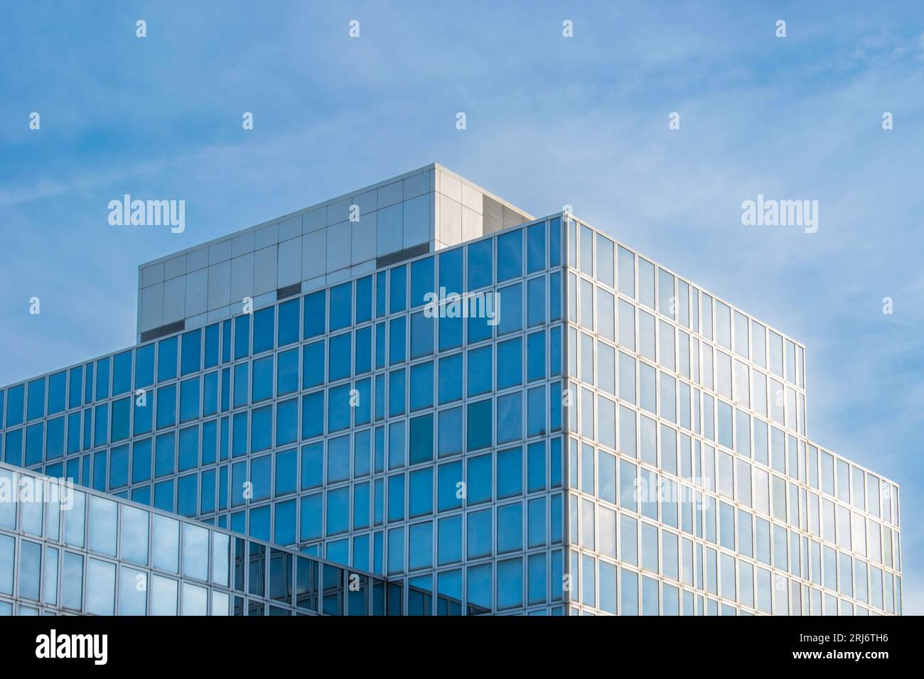 Contemporary commercial building with blue tinted windows reflecting ...