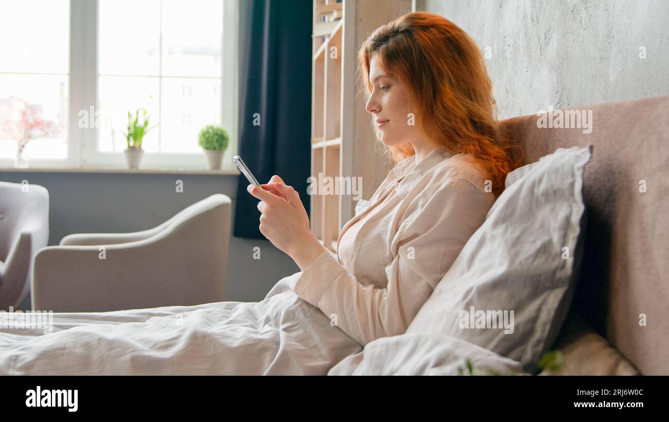 Relaxed Caucasian girl woman in bed at tranquil morning routine after ...