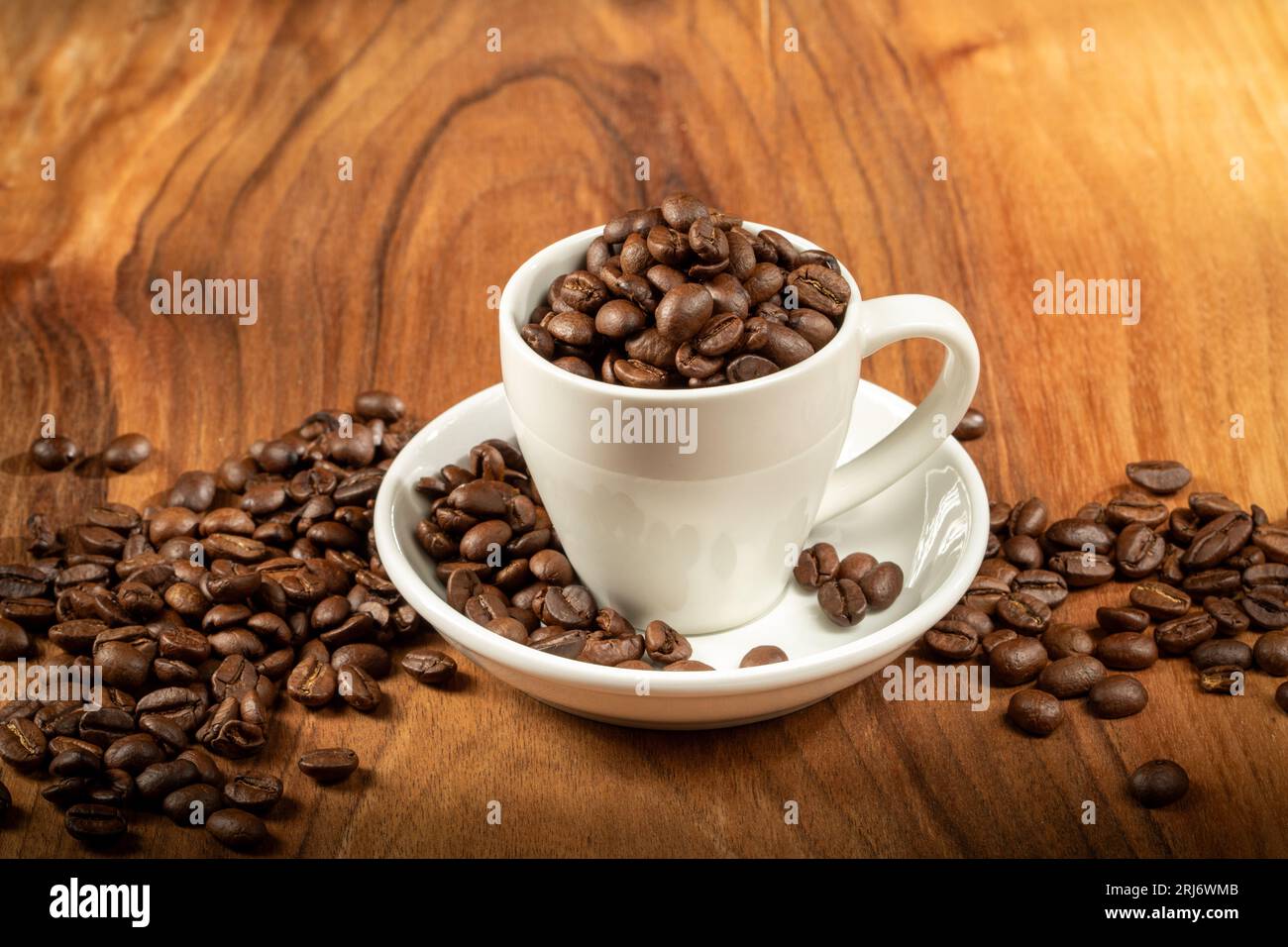Coffee theme. A ceramic cup filled to the brim with coffee beans stands ...