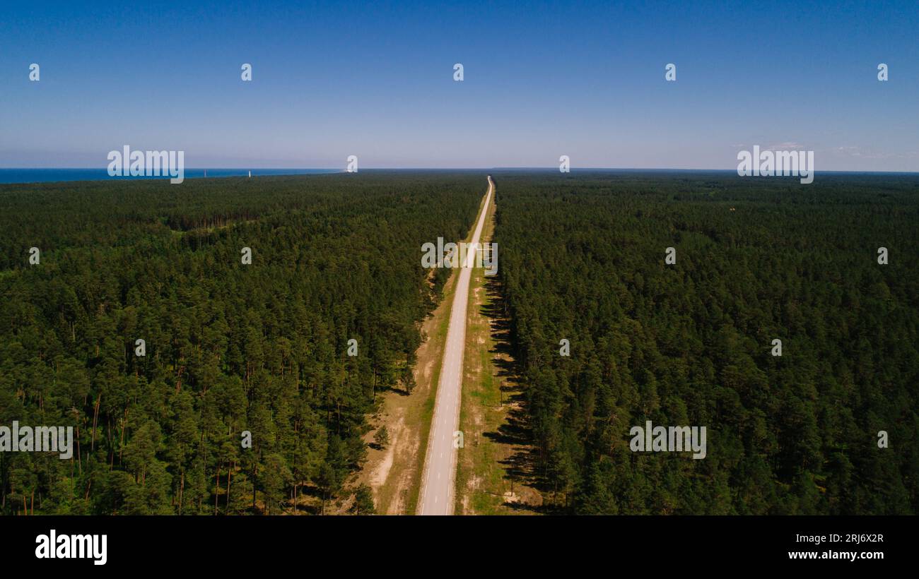 An aerial view of a rural landscape featuring a long road winding ...