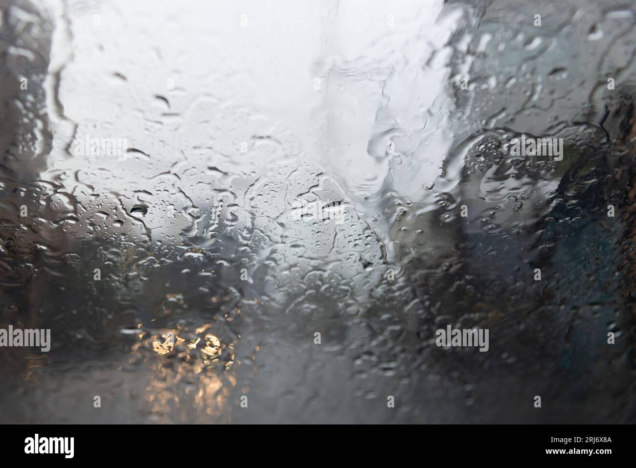 Drops of rainwater on the windshield of a car forming designs and ...