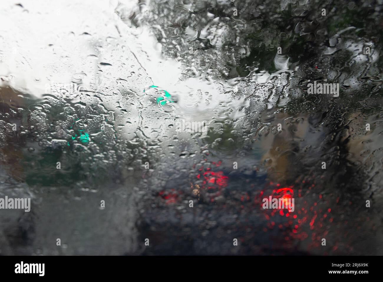 Drops of rainwater on the windshield of a car forming designs and ...