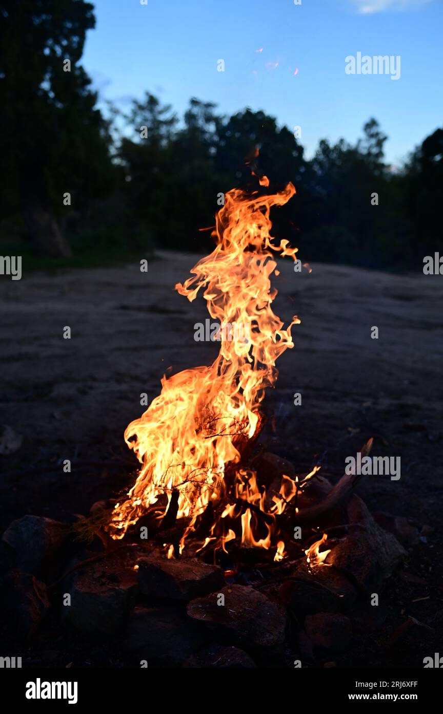 A glowing orange fire illuminates the vast desert landscape ...
