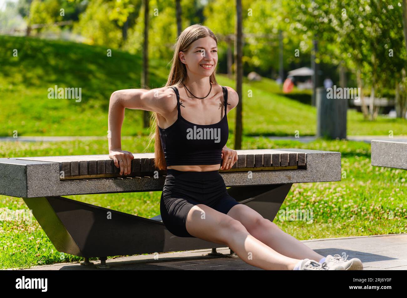 Athlete woman doing push-ups on bench in park. Training triceps workout ...