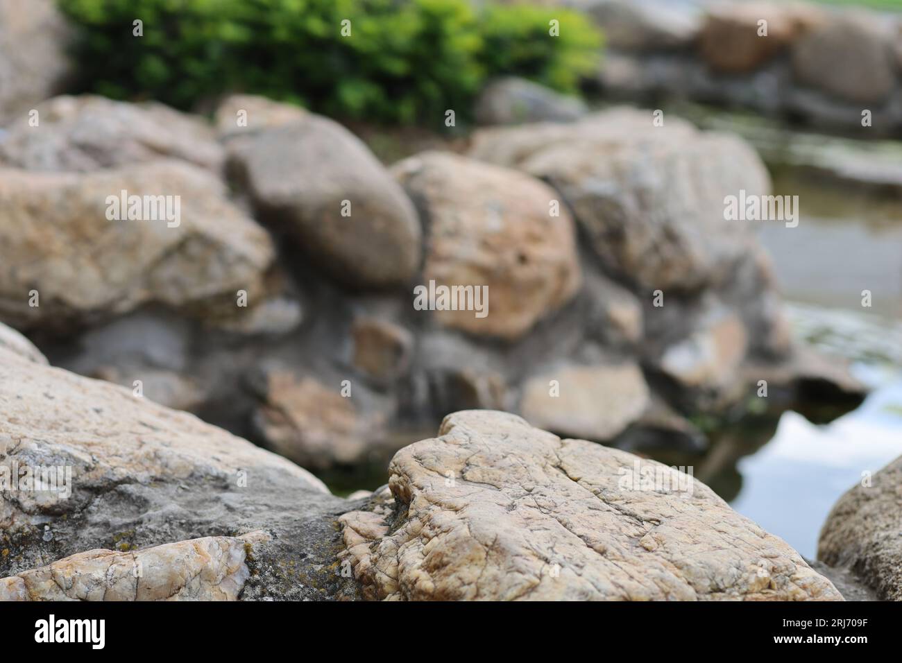A scenic view of a beach shoreline featuring large rocks at the edge of ...