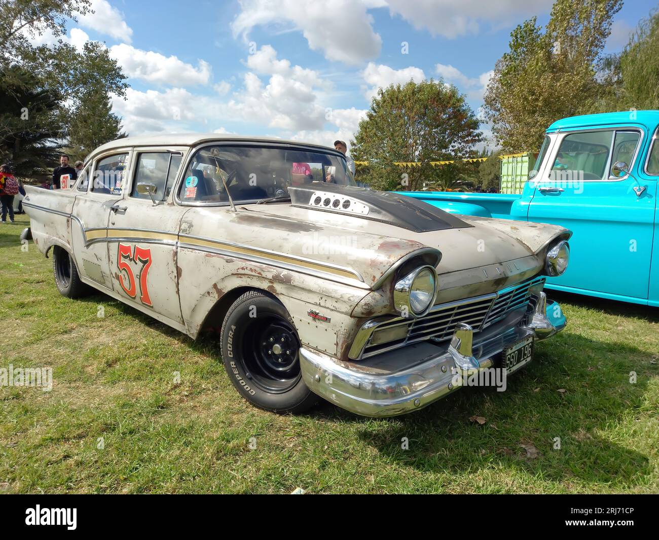 Old worn rusty 1957 Ford Custom 300 V8 292 Tudor sedan hot rod on the lawn. Nature, grass, trees ...