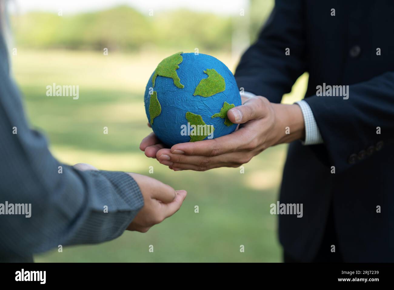 Earth day concept, businessman giving Earth globe to colleague as CSR ...