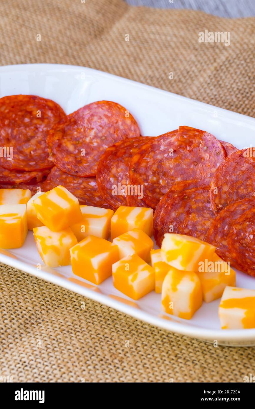 A long white platter with sliced cheese and pepperoni Stock Photo - Alamy