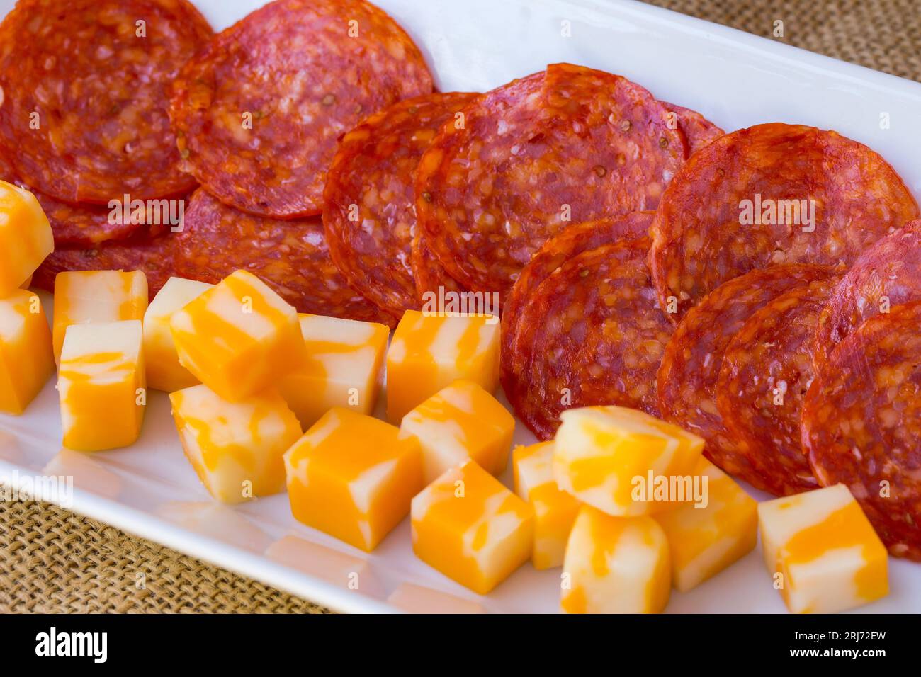 A long white platter with sliced cheese and pepperoni Stock Photo - Alamy