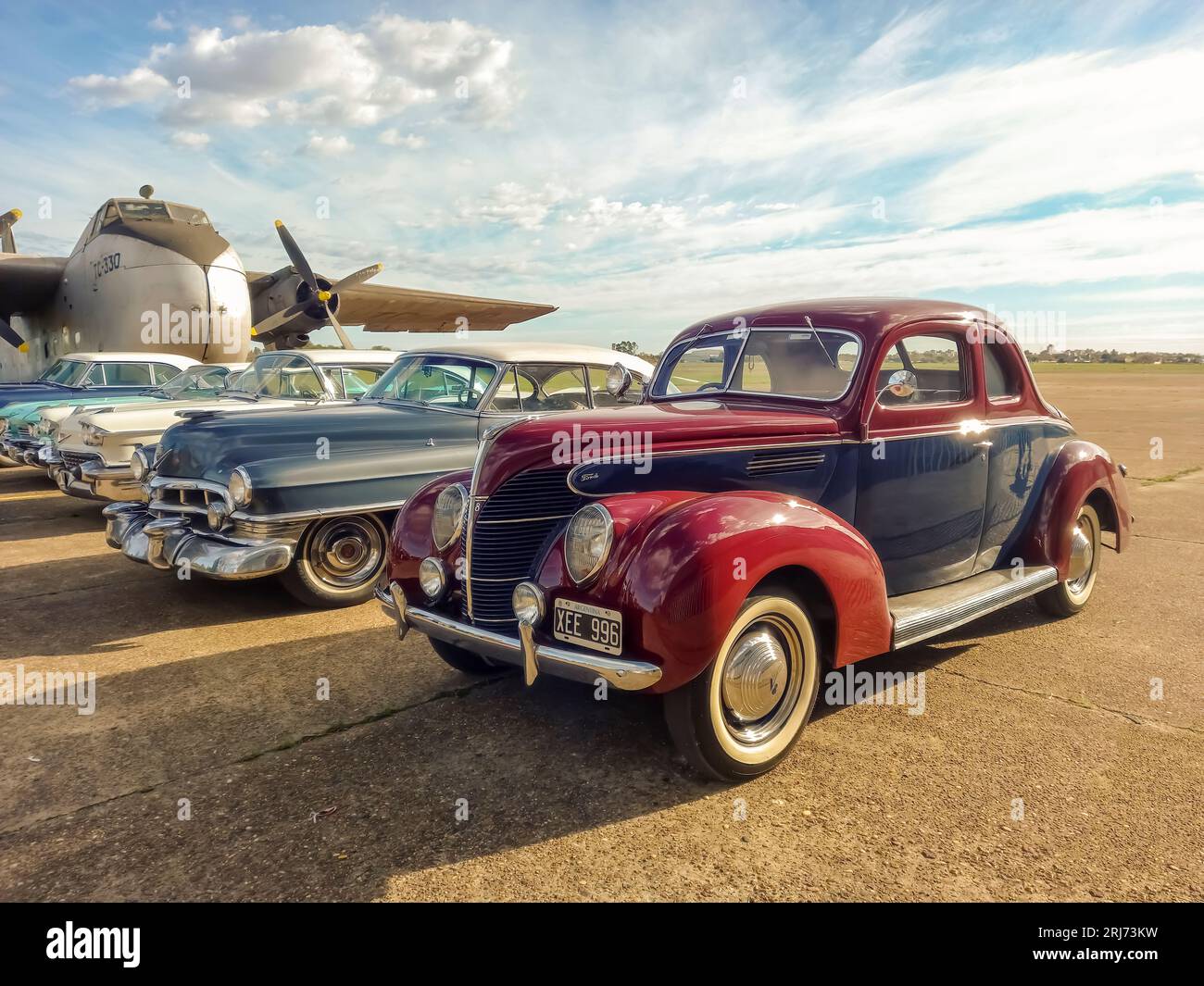 Old red and blue 1939 Ford V8 Standard coupe at an airstrip. CAACMACH ...