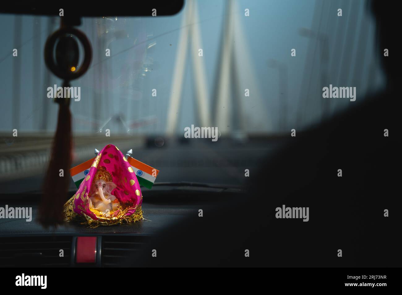 A small statue of the Hindu god Ganesh on the dashboard of a car in ...