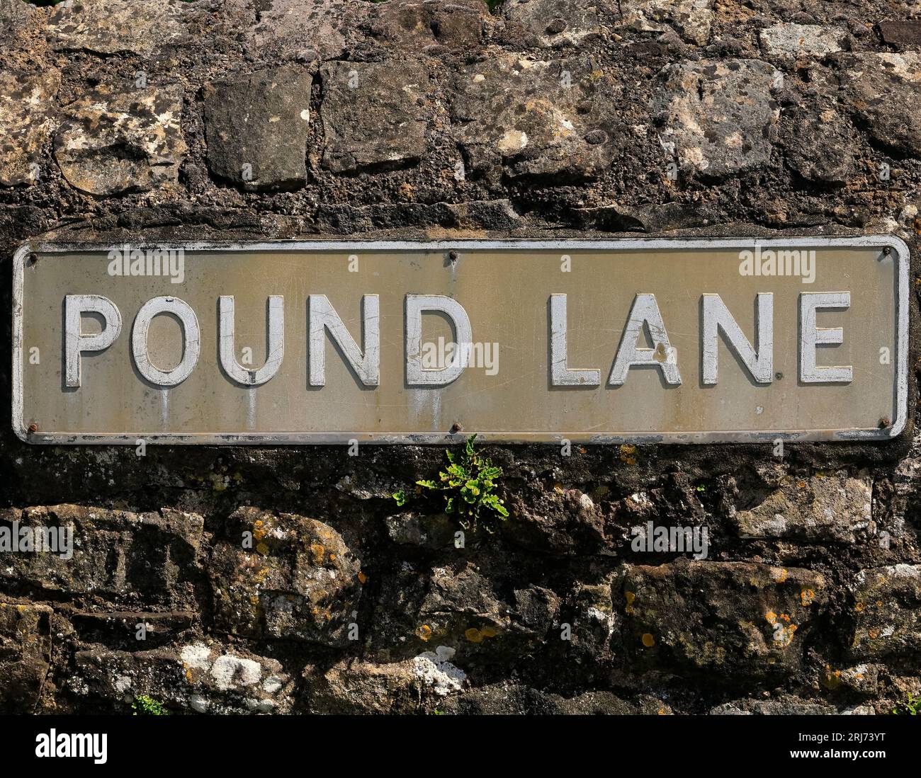Sreet sign for Pound Lane against a stone wall. Caerwent village, South ...