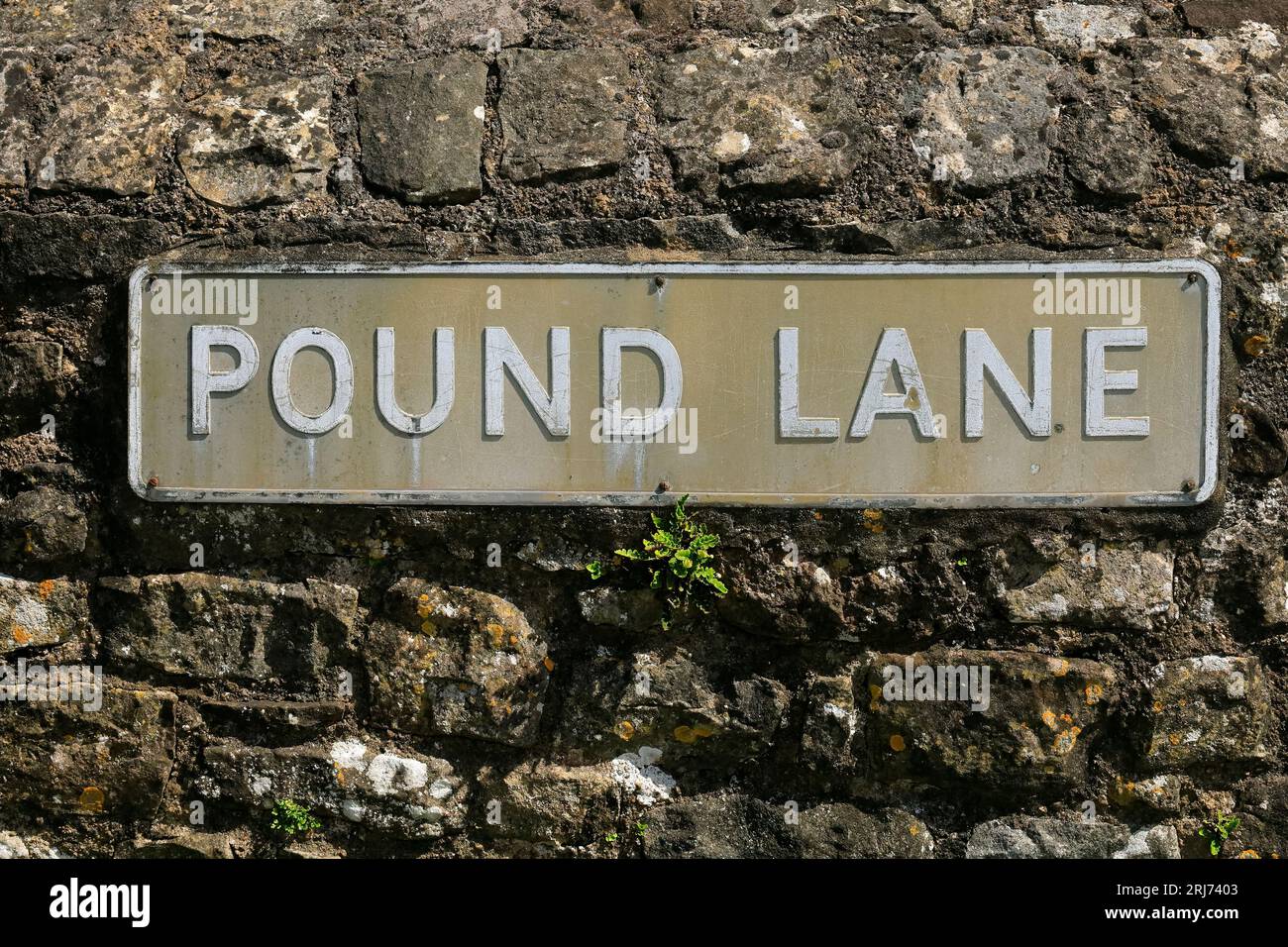 Sreet sign for Pound Lane against a stone wall. Caerwent village, South ...