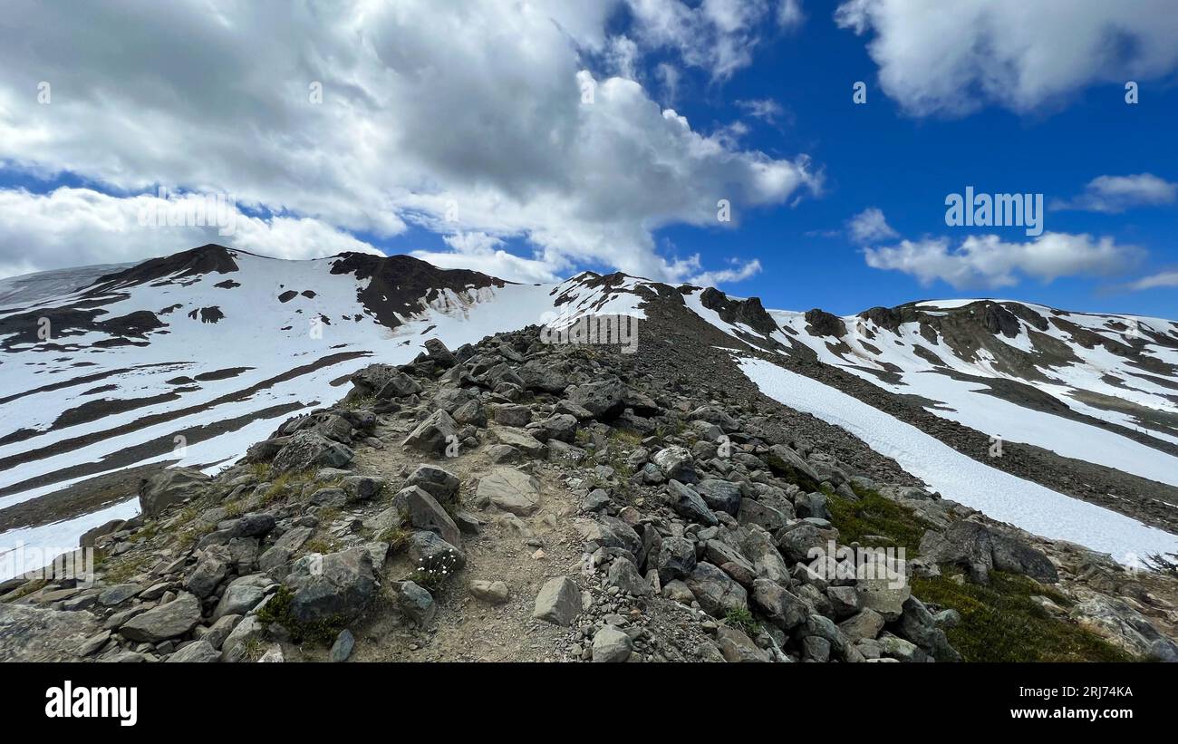 A snow-capped mountain range against the backdrop of blue sky. Panorama ...
