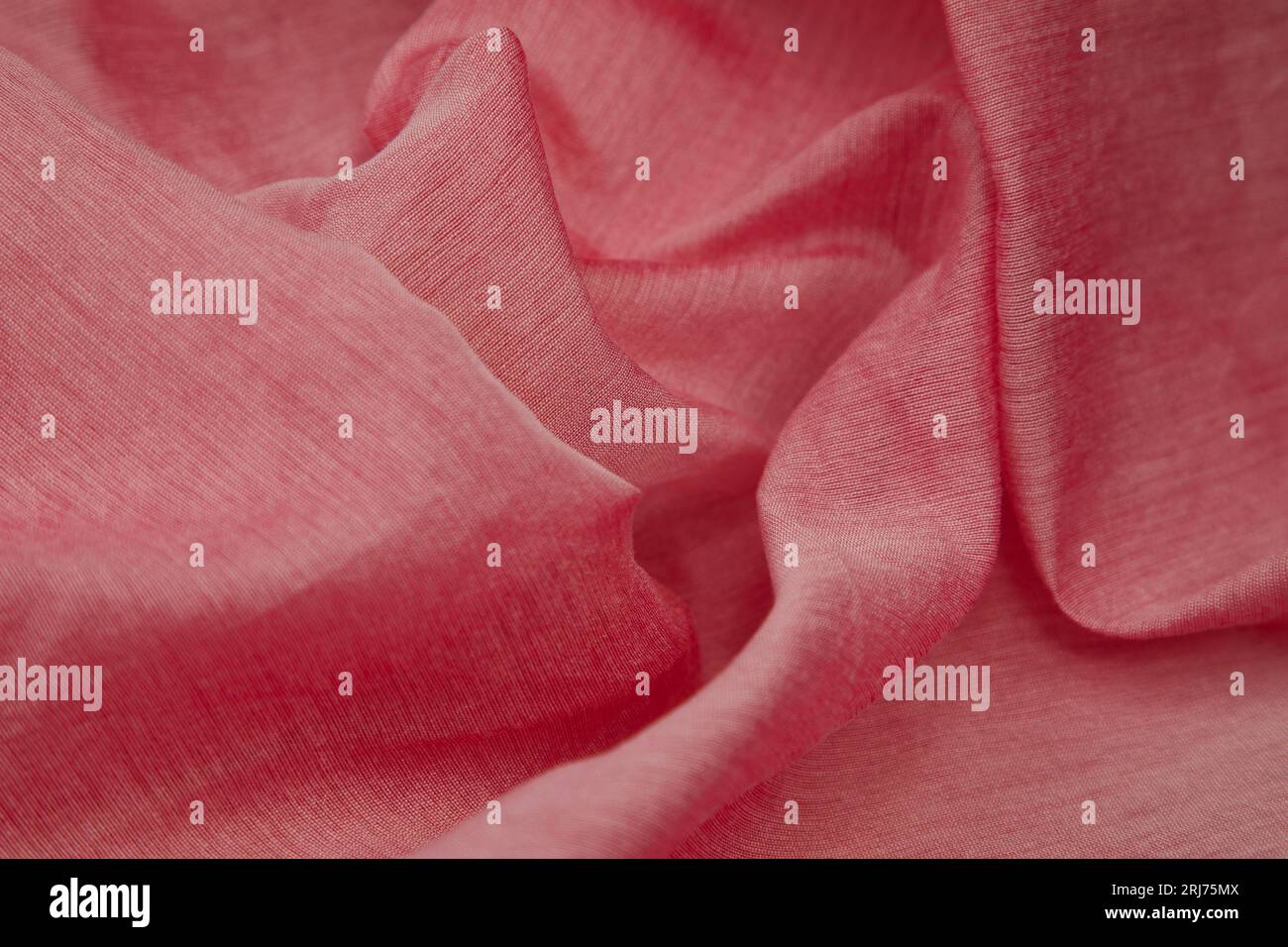 A high resolution closeup shot of a light red fabric, featuring a plain ...