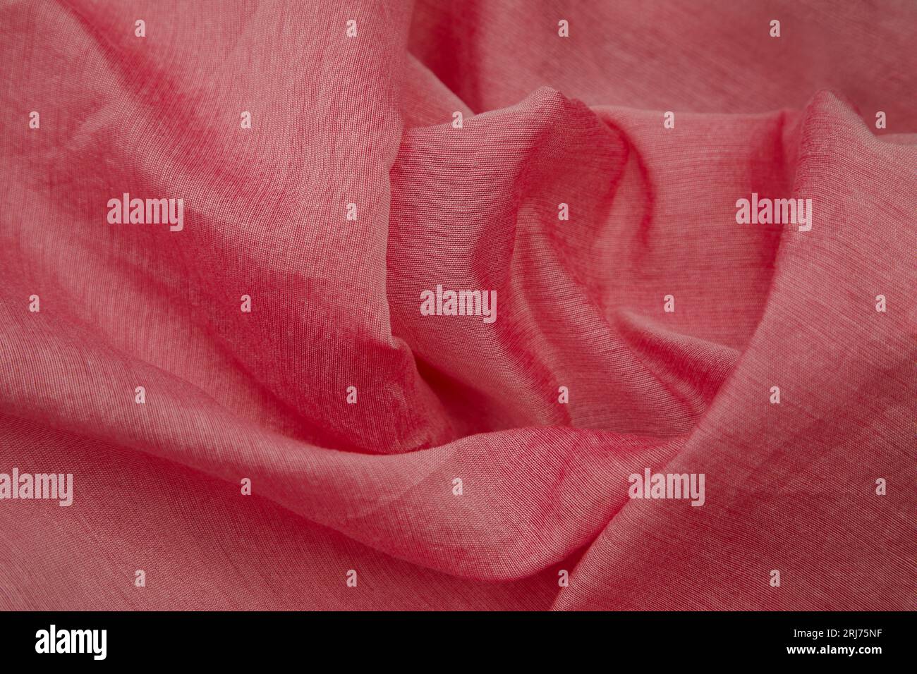 A high resolution closeup shot of a light red fabric, featuring a plain ...