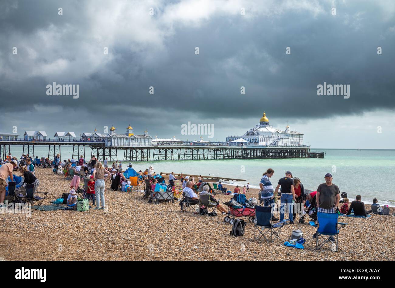 People on the beach next to the Victorian-era Eastbourne Pier on a ...