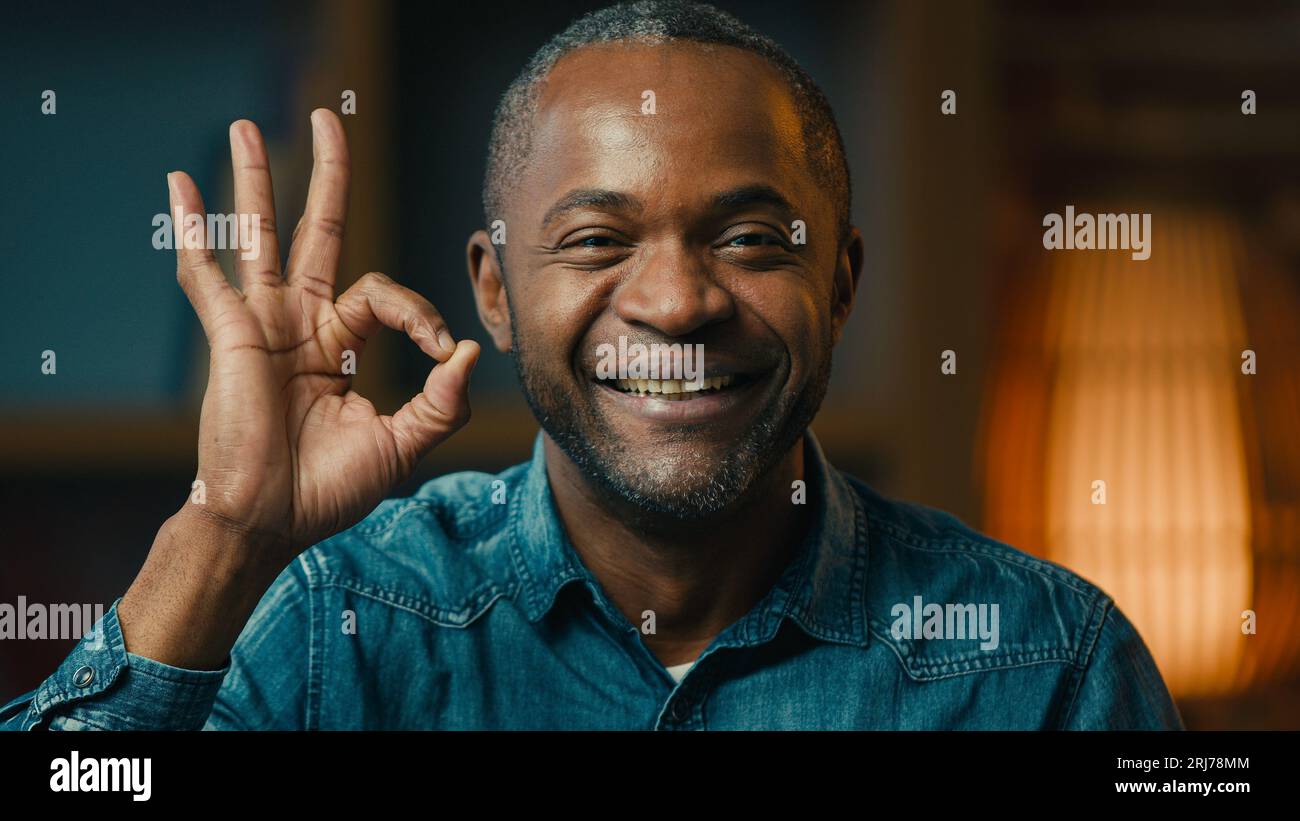 Close-up happy mature african american man showing ok sign approval gesture satisfied smiling ...