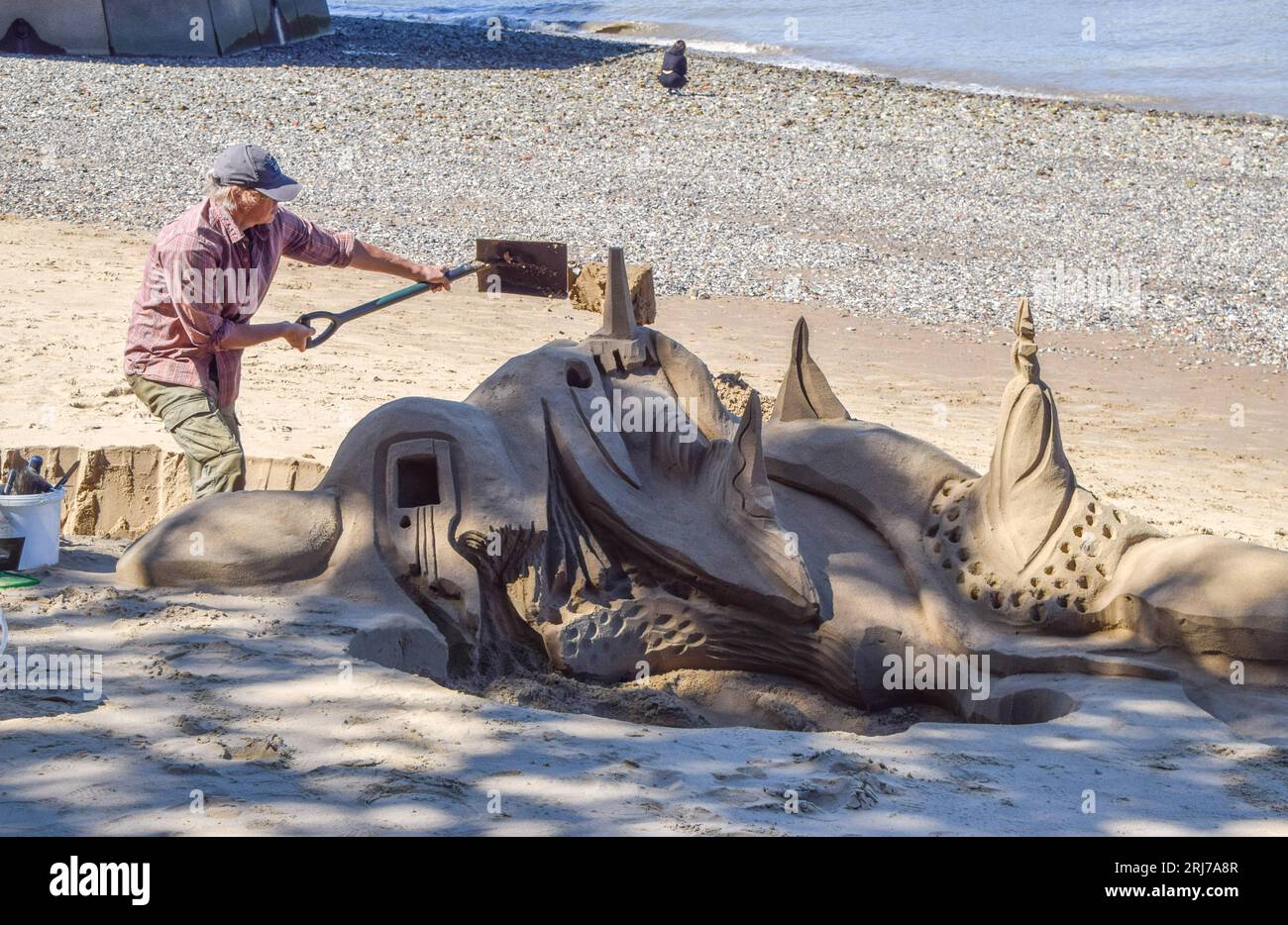 London, UK. 21st August 2023. An artist creates a sand sculpture next ...