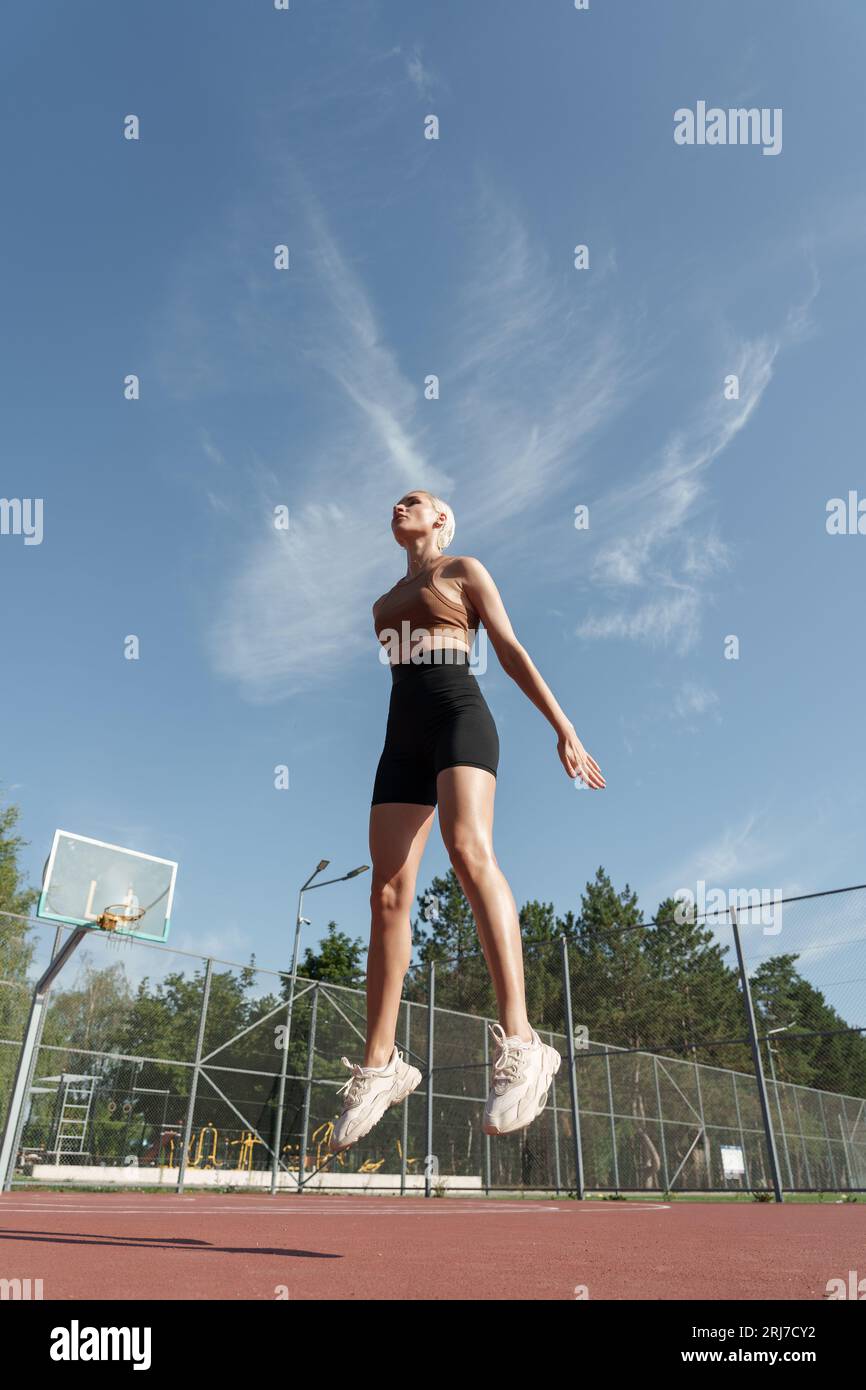 Young Woman Jumping on Basketball Court Stock Photo - Alamy