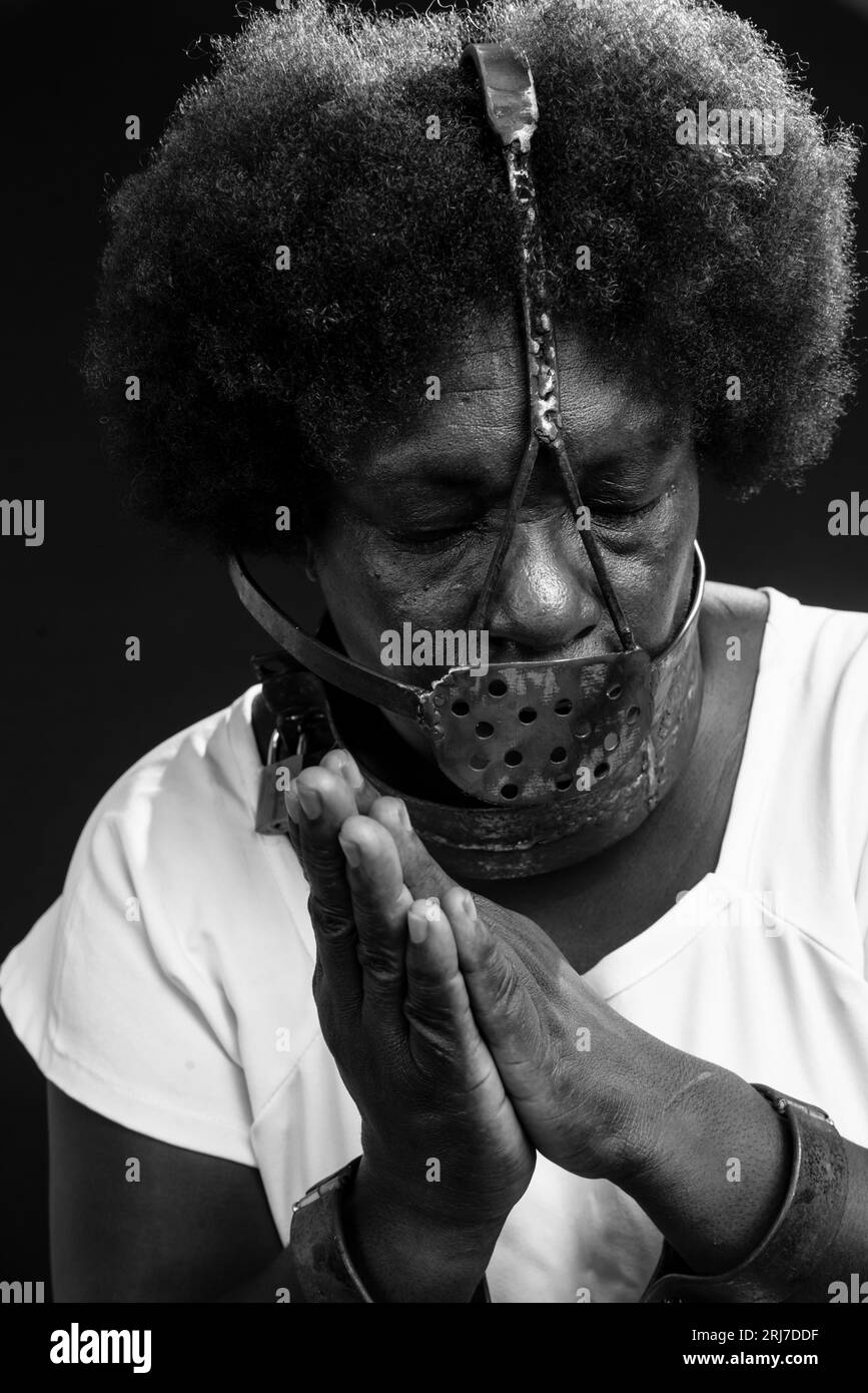 Portrait of the face of a black woman with an iron mask on her face, representing the slave ...