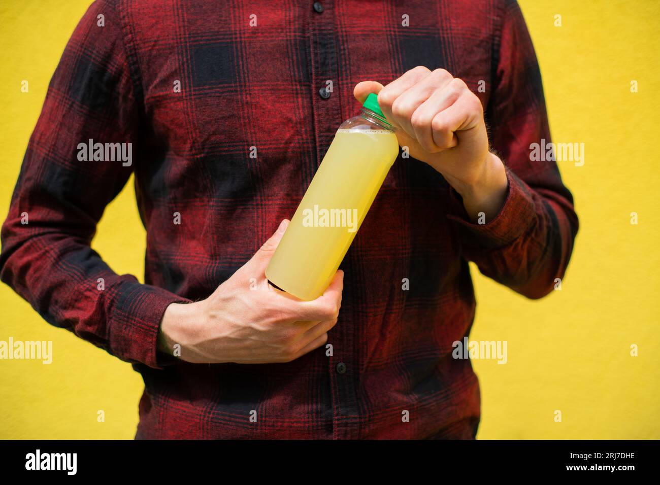 Close-up hand of unrecognizable man in red shirt holding Orange ...