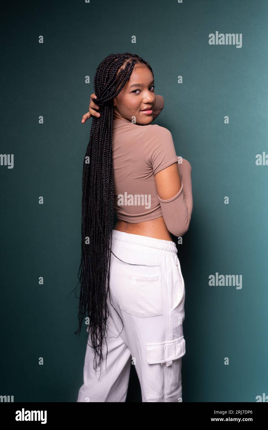 Beautiful young woman, standing, messing with her long hair. Isolated ...